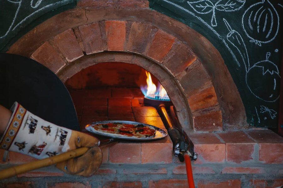 Pizza baking in wood-fired traditional oven