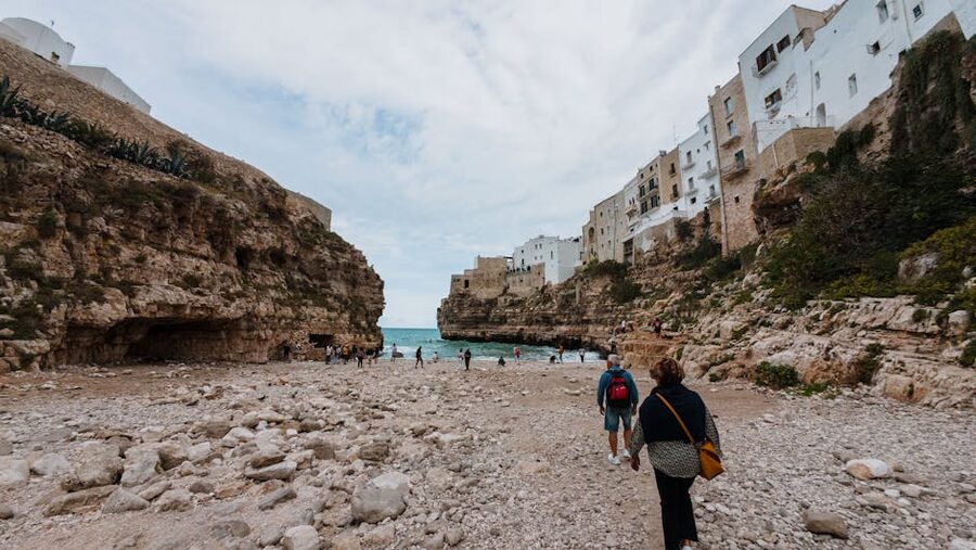 Polignano rocky beach with tourists