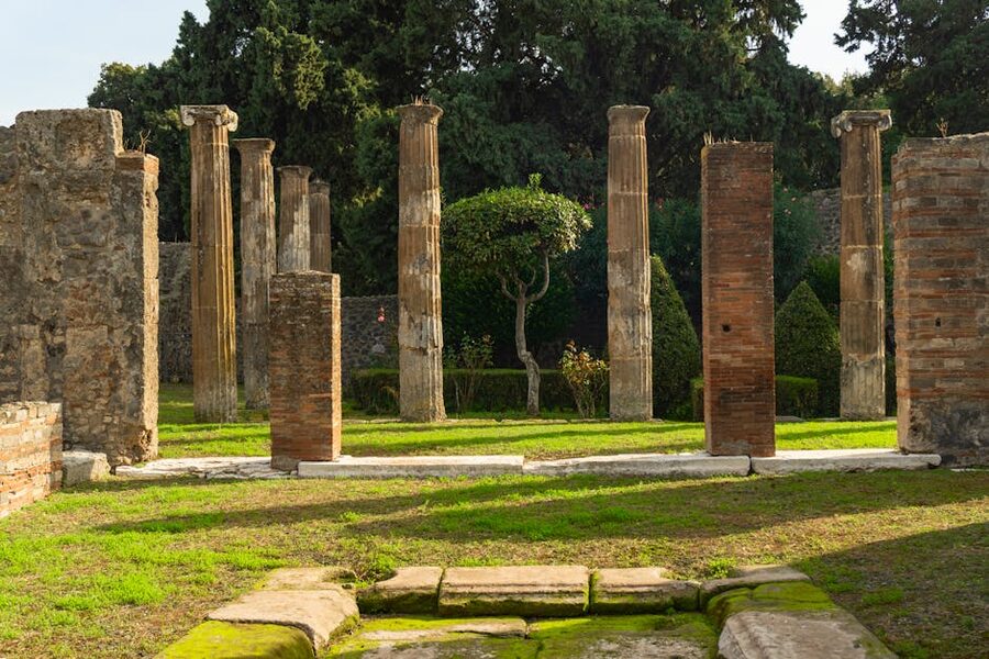 Historic columns in Pompeii with garden backdrop