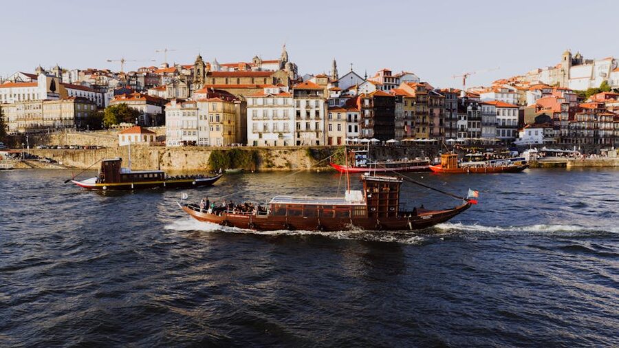 Boats sailing on Douro River Porto historic architecture