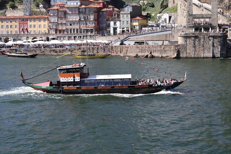 Traditional rabelo boat cruising on the Douro River with Porto buildings in the background