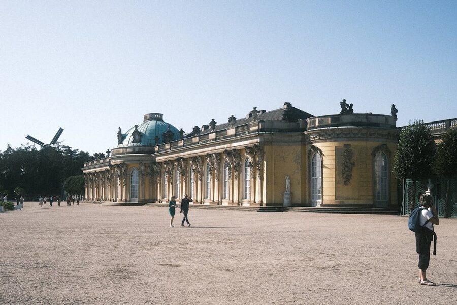 Visitors walking along the path toward Sanssouci Palace entrance