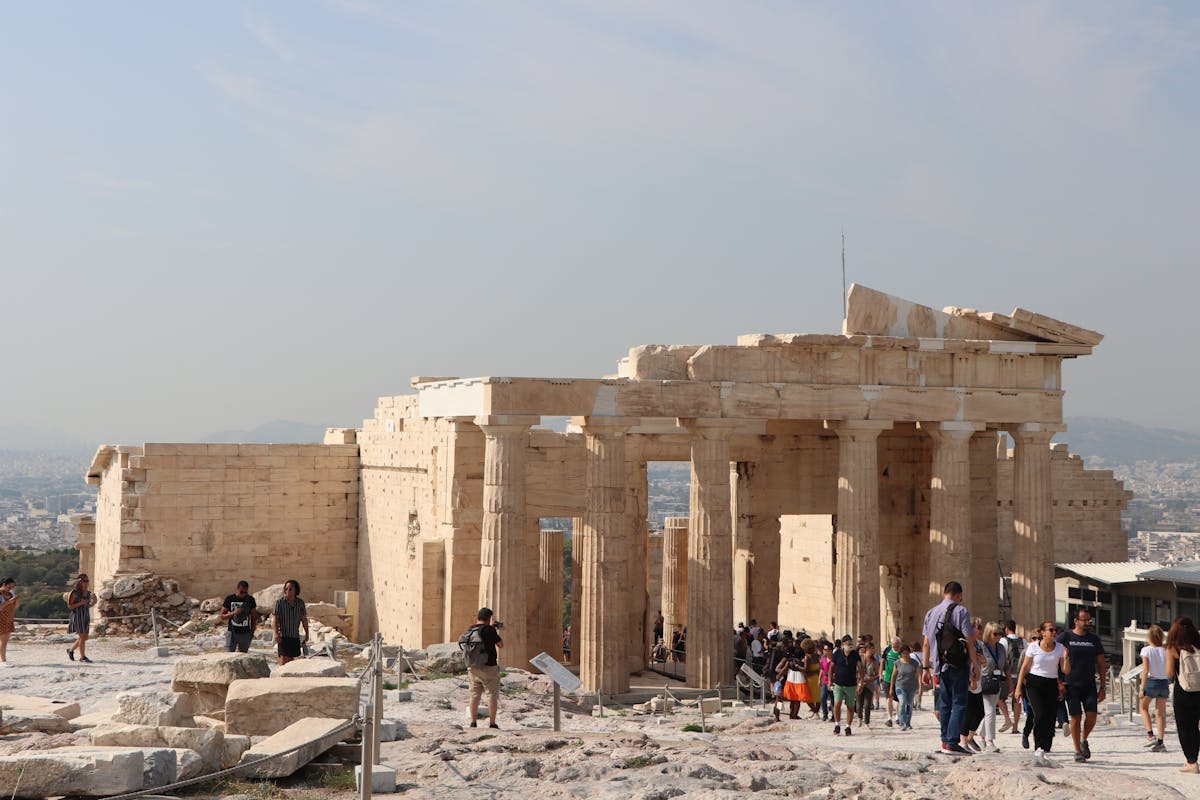 Visitors exploring the historic Propylaea gateway at the Acropolis in Athens