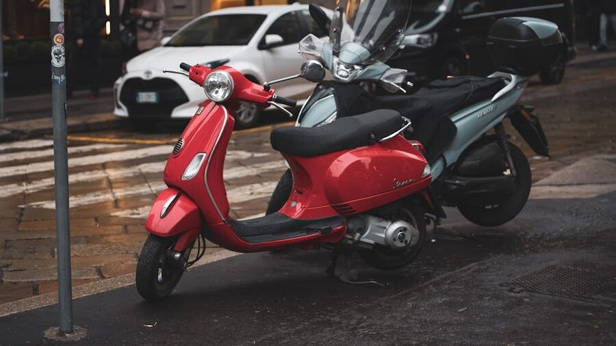 Red Vespa scooter on rainy street
