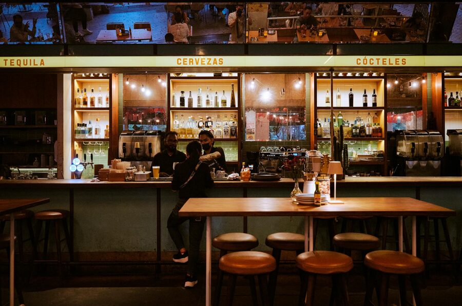 Bar interior at night with patrons and warm lighting
