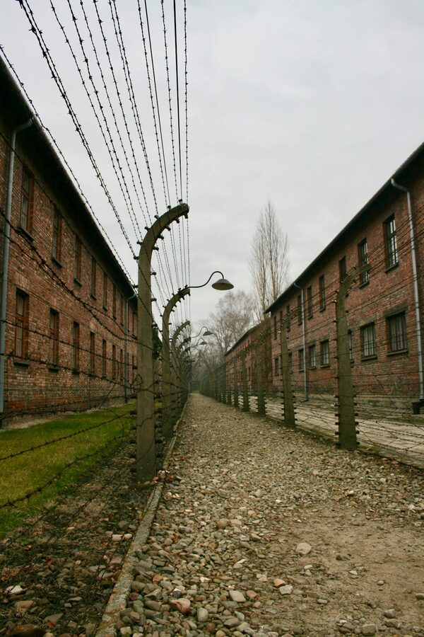 Pathway between barbed wire fences at a concentration camp memorial