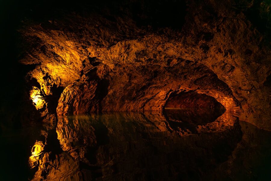 Underground cave with reflective water and stalactites