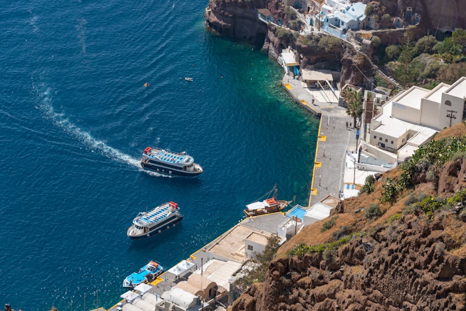 Sailboat crossing the Santorini caldera at golden hour