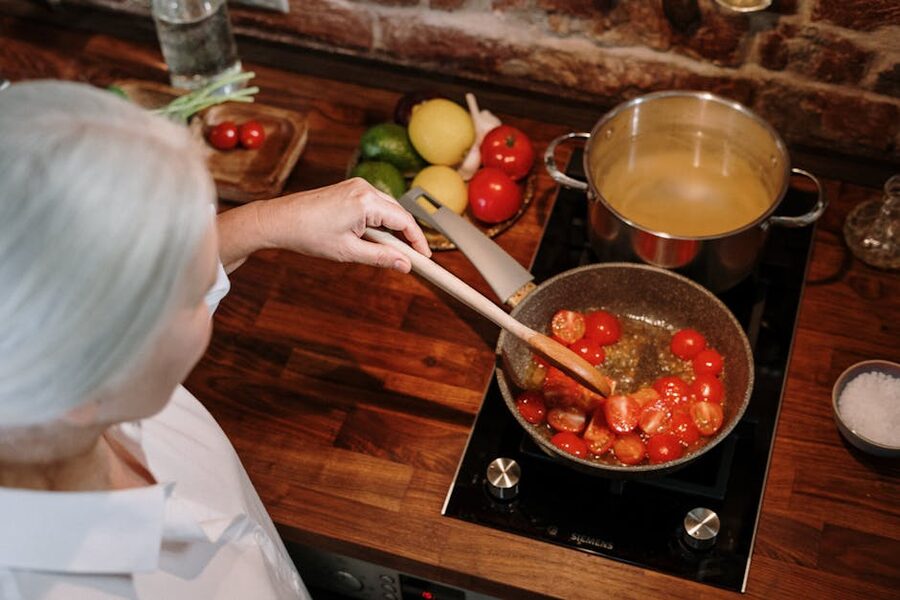Senior woman preparing tomato sauce