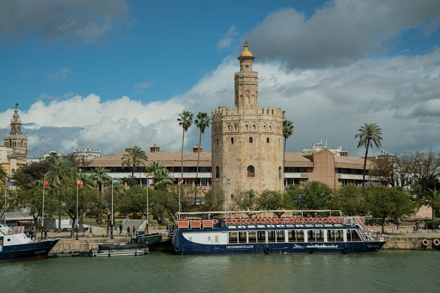 River cruise boat docked in front of Torre del Oro