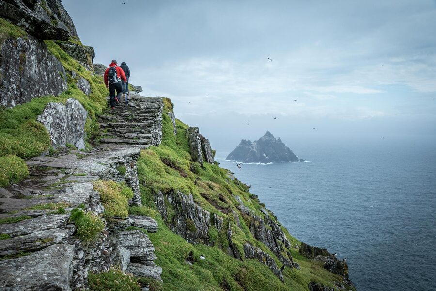 Hikers on the ancient stone steps of Skellig Michael