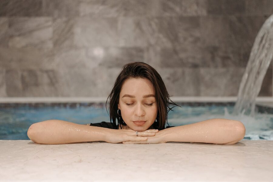Woman relaxing at indoor spa pool