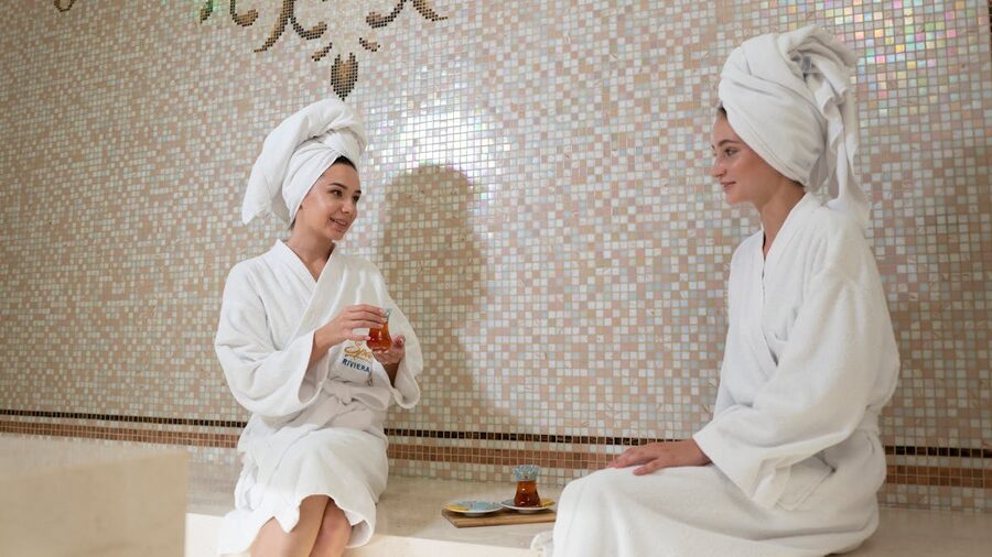 Women bonding over tea at spa in bathrobes