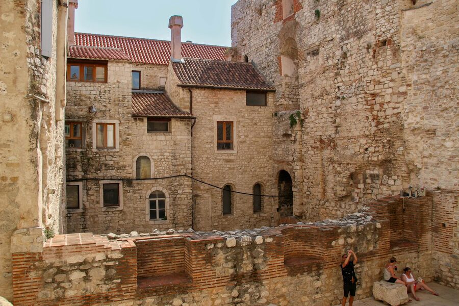 People sitting beside stone building in Split