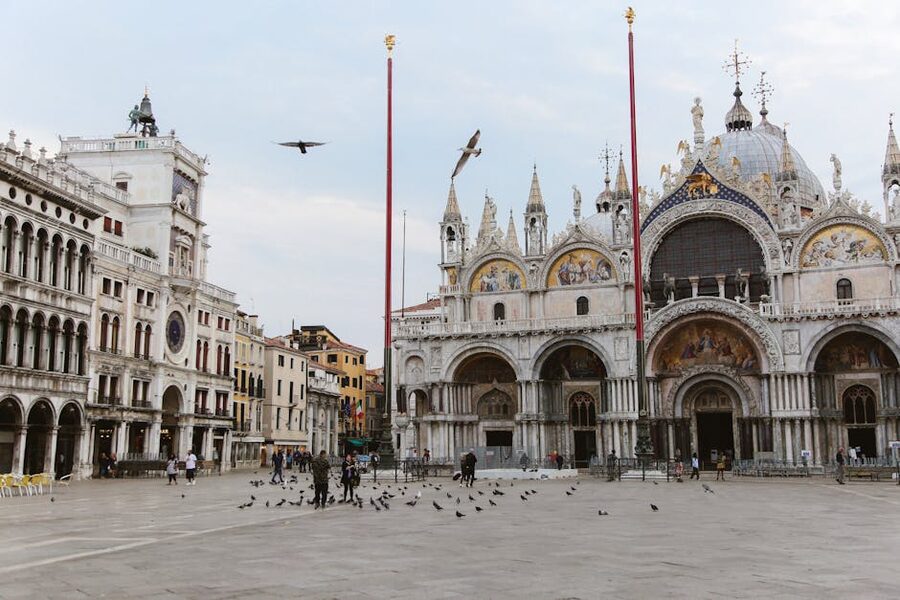 Tourists and pigeons in front of St Mark's Basilica in St Mark's Square