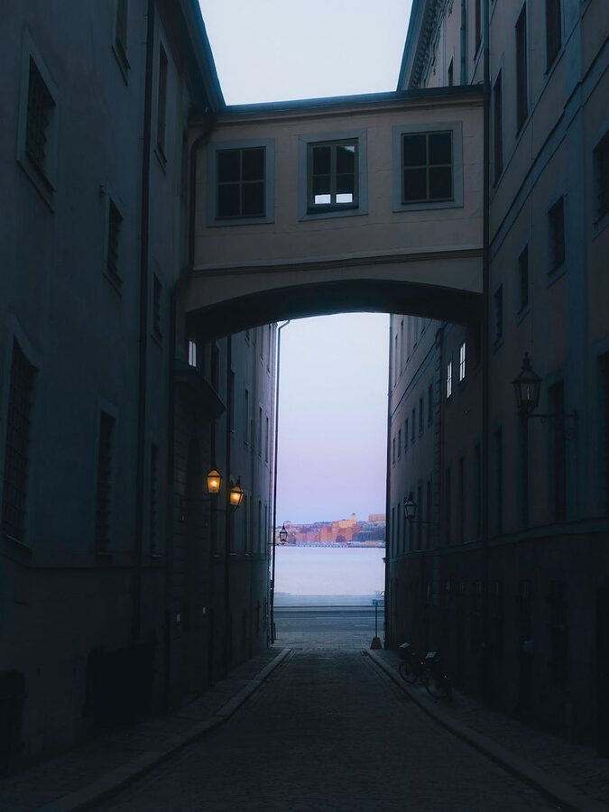 View through a narrow Stockholm alley towards water and distant buildings