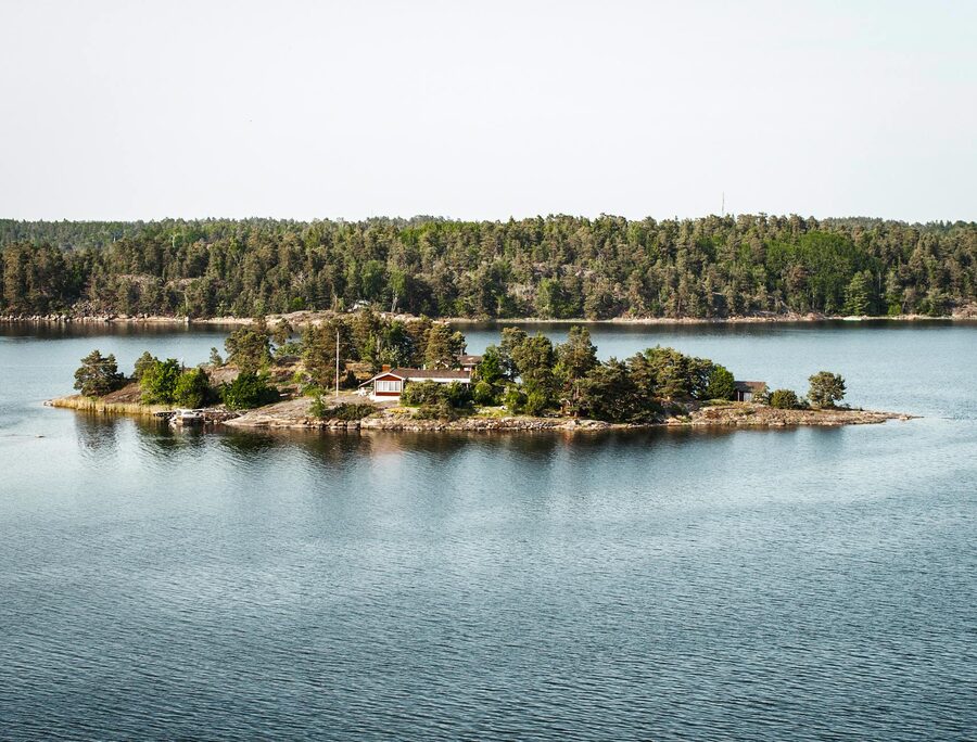 Red cottage on a Stockholm archipelago island surrounded by calm water
