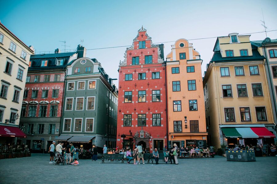People enjoying Gamla Stan main square with colourful historic buildings
