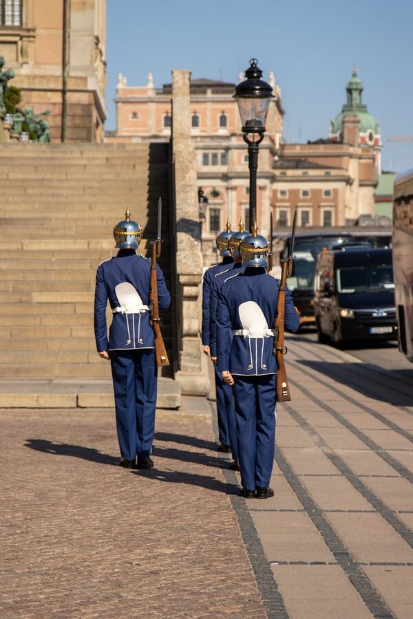 Royal guards in blue uniforms marching outside Stockholm Palace