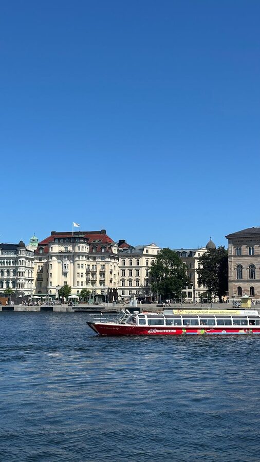 Tour boat cruising past historic waterfront buildings in Stockholm