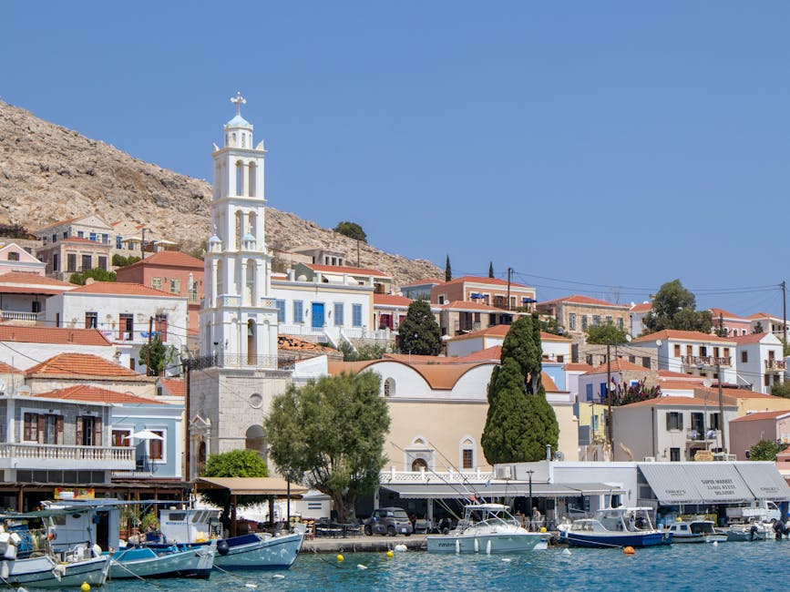 Traditional fishing boats in the port with Symi town behind