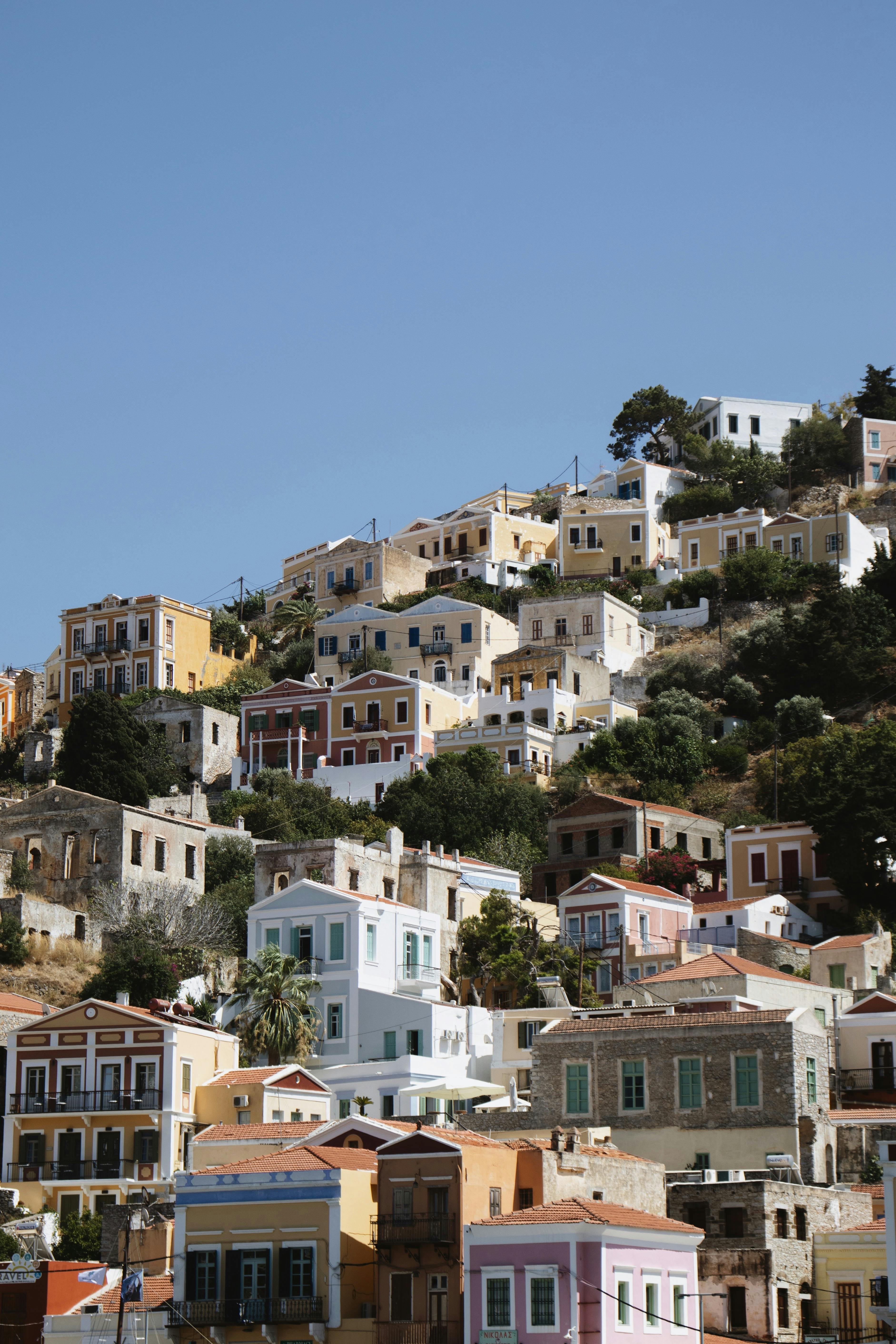 Colorful hillside houses in Symi, Greece, under a clear blue sky