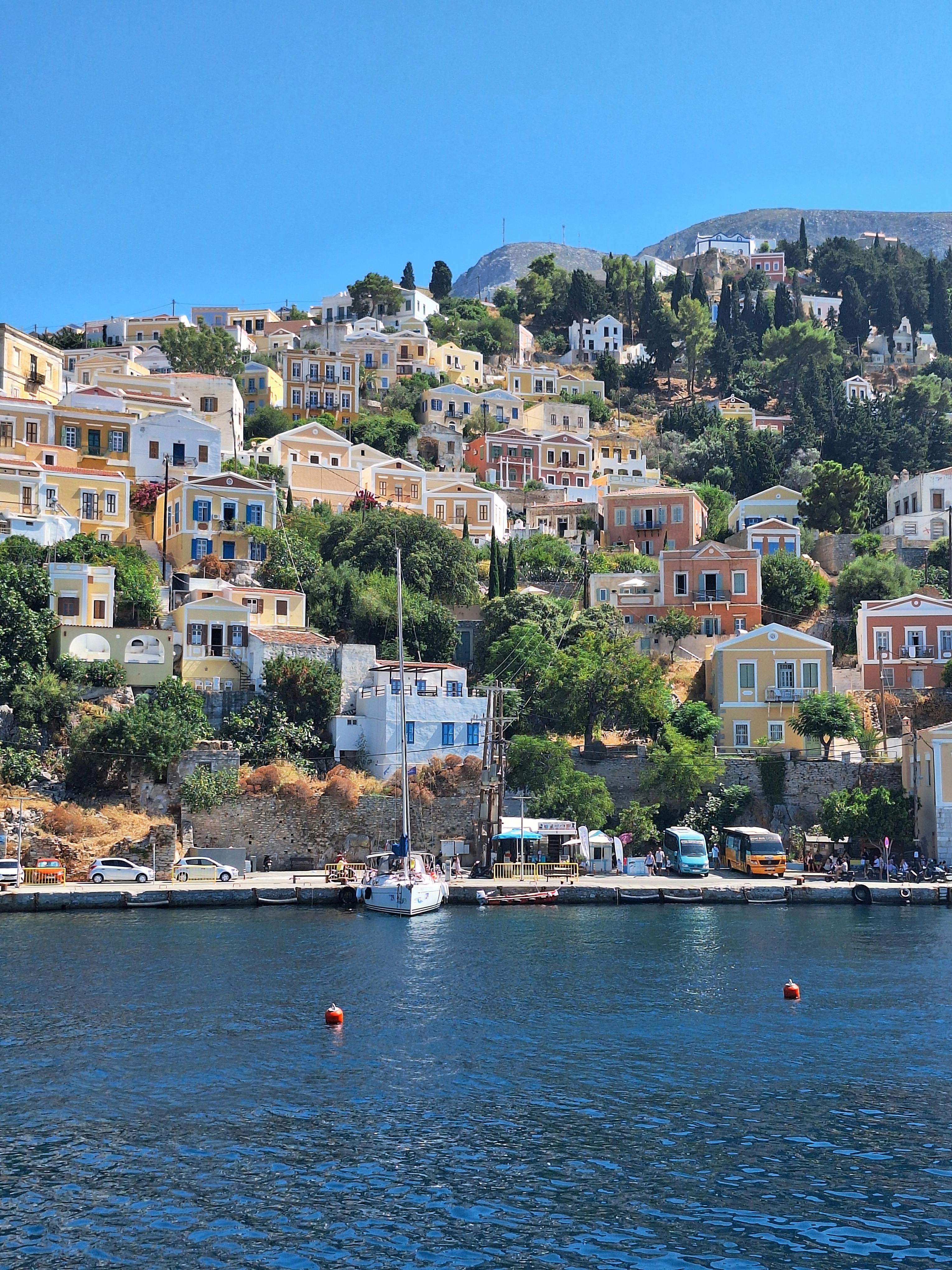 Colourful houses on Symi Island hillside near a calm harbor in Greece