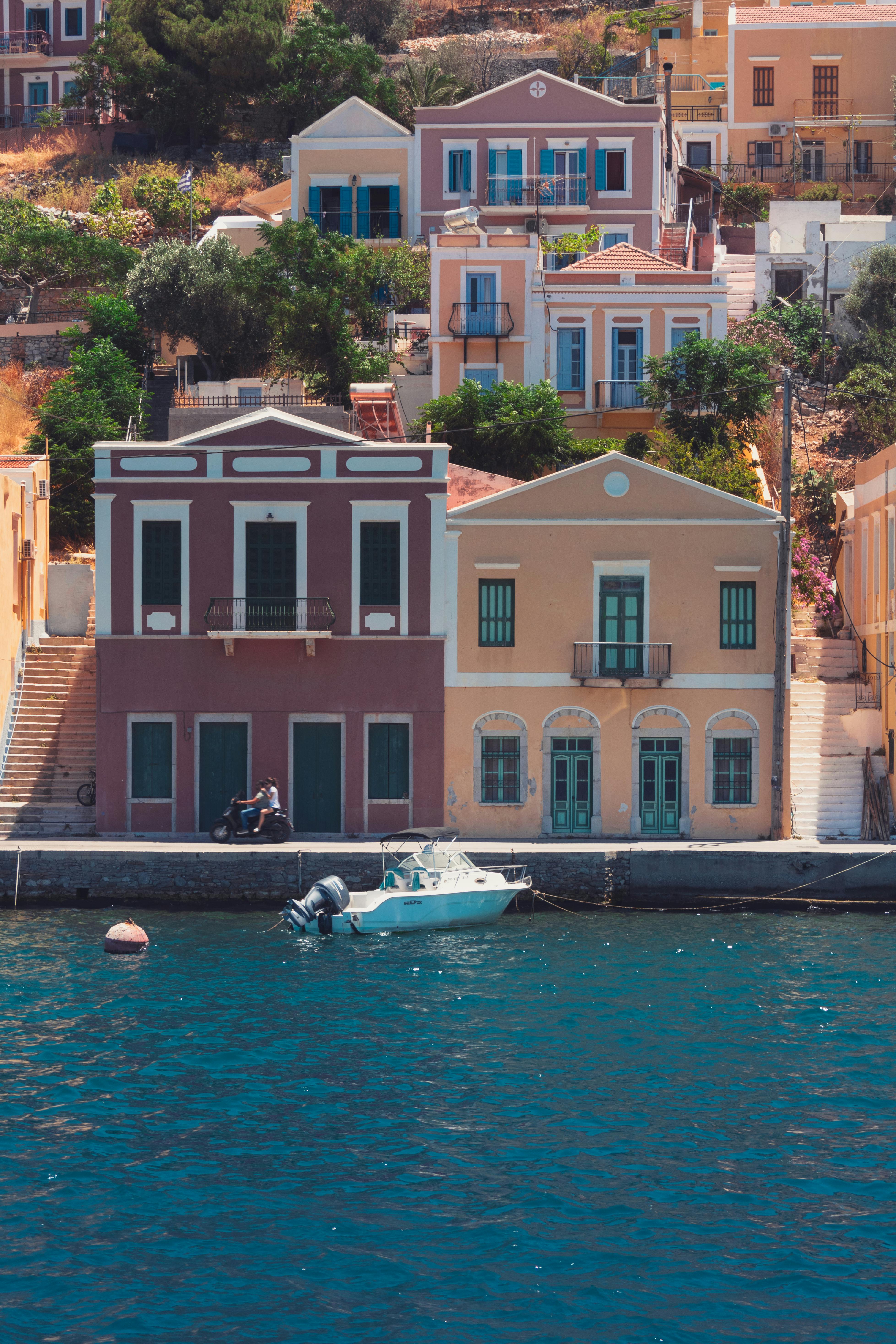 Waterfront houses on Symi Island with a motorboat scene
