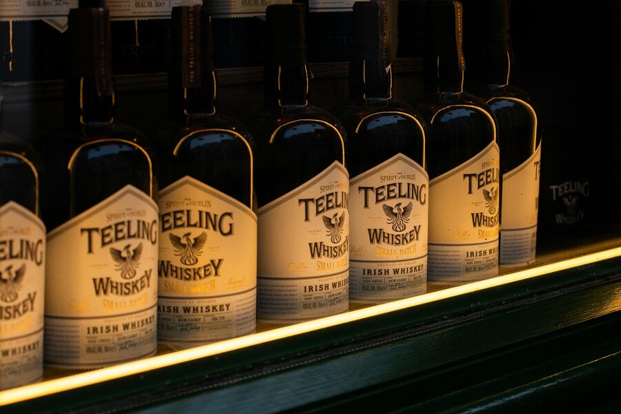 Row of Teeling Irish whiskey bottles with soft golden lighting