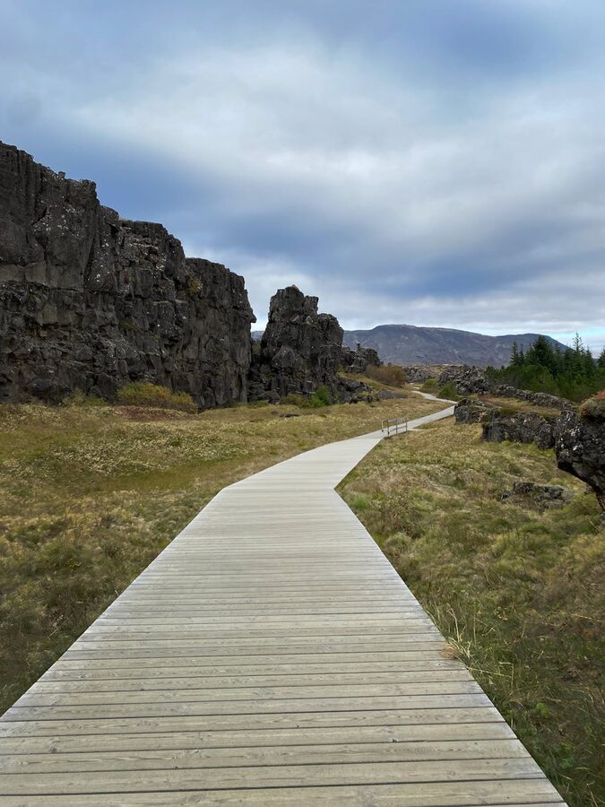Boardwalk path between rock formations and meadows at Thingvellir National Park