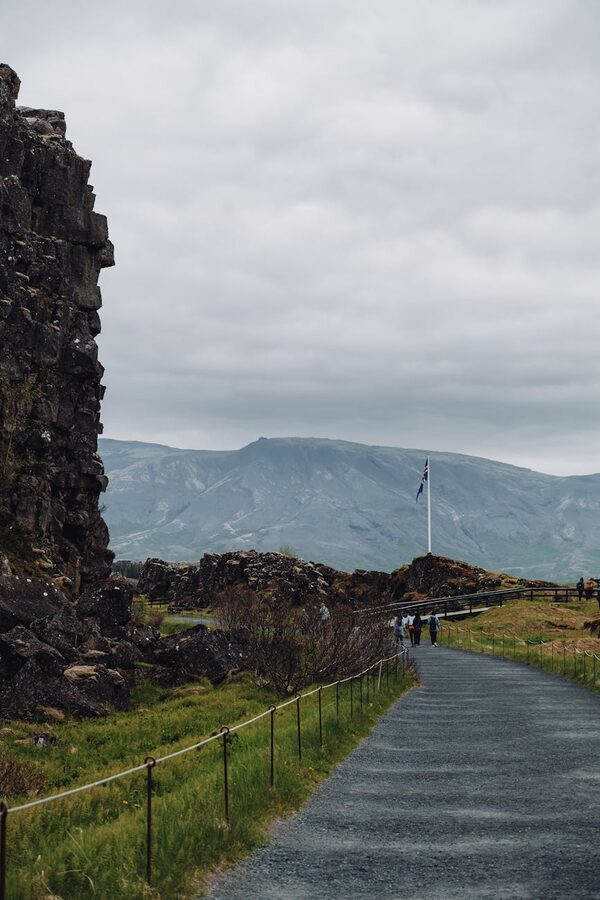 Walking trail through Thingvellir National Park with mountains and overcast sky