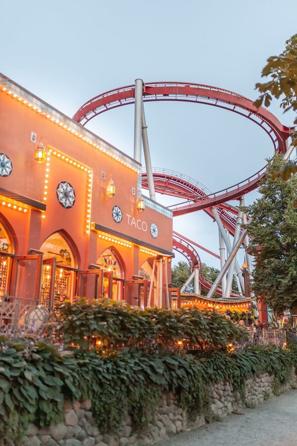 Tivoli rollercoaster and food stands in evening light