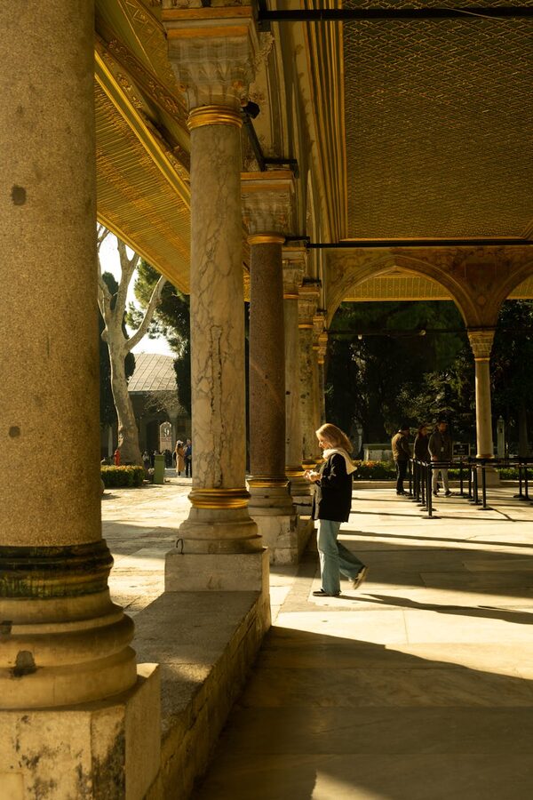 Woman walking through the sunlit courtyard of Topkapi Palace