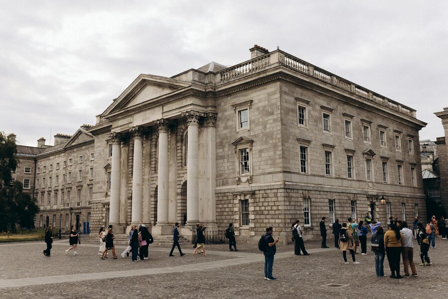 Neoclassical facade of Trinity College Dublin with visitors
