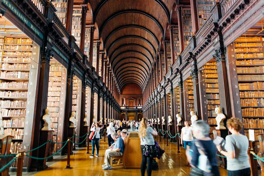 Visitors walking through the Long Room at Trinity College Library Dublin