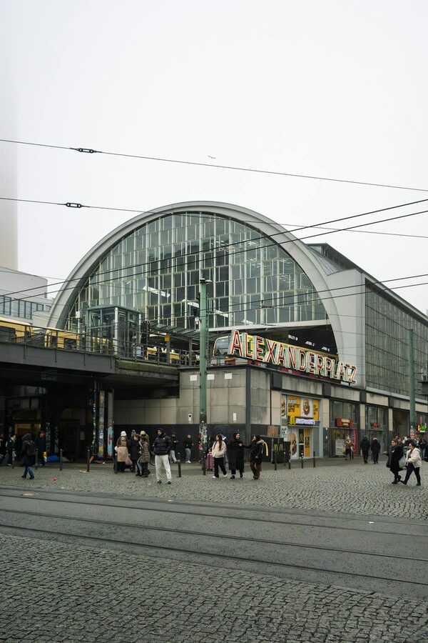 Alexanderplatz train station in Berlin with people walking near modern buildings