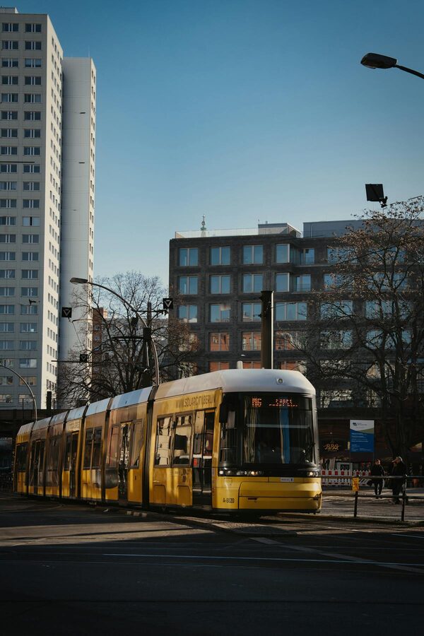 Yellow tram passing through Alexanderplatz in Berlin with modern architecture