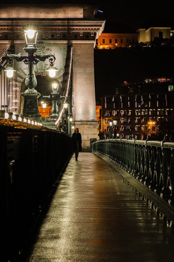 Woman walking on Chain Bridge Budapest at night
