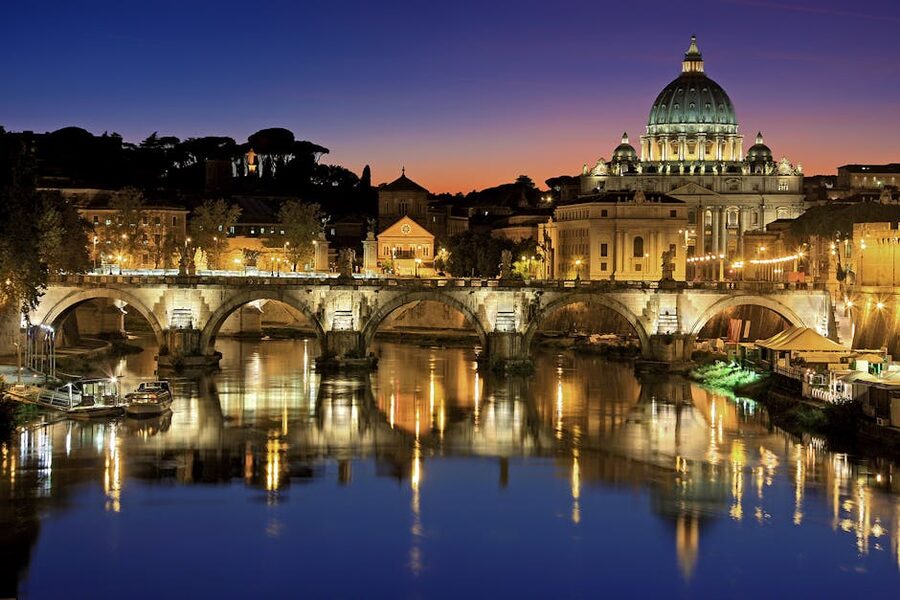 St Peters Basilica and St Angelo Bridge reflected in the Tiber River at sunset