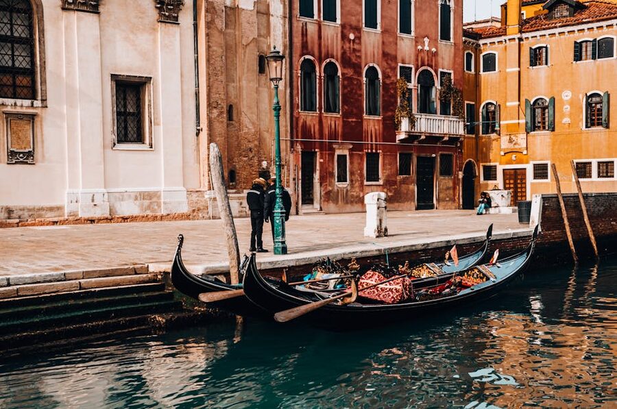 Venice gondolas docked by historic architecture