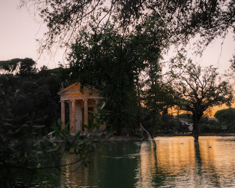Temple of Aesculapius reflecting in a pond at Villa Borghese, Rome