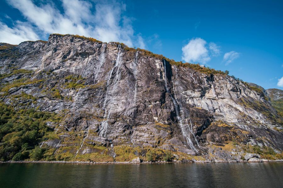Waterfall cascading down rocky cliffs in a Norwegian fjord