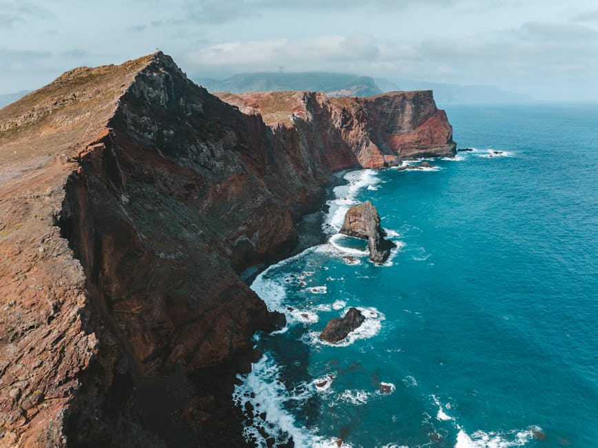 Aerial drone view of Madeira cliffs and clear blue ocean