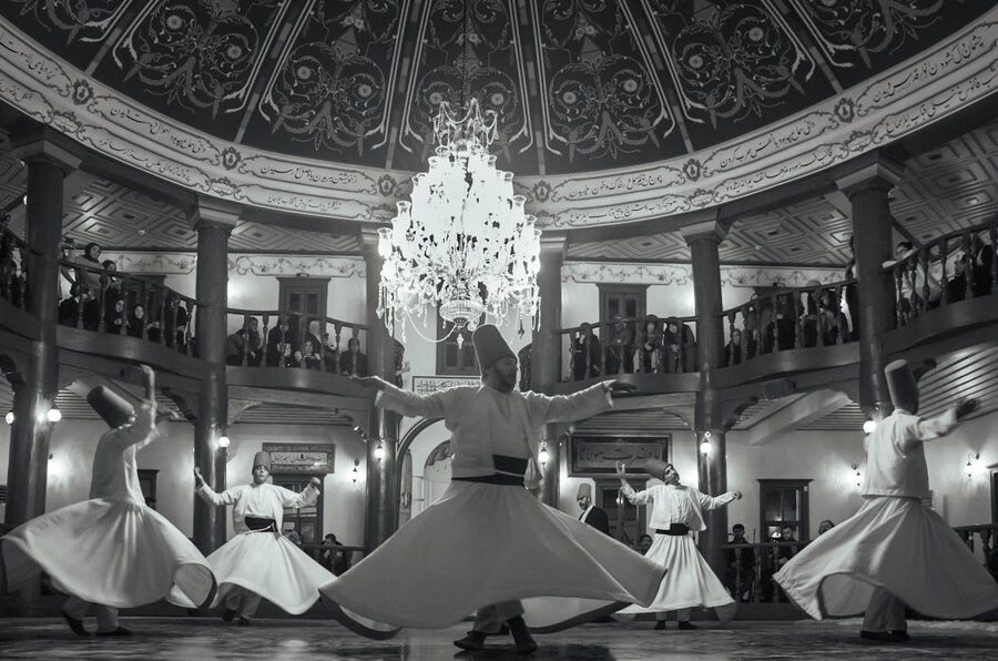 Whirling dervishes ritual indoors in black and white