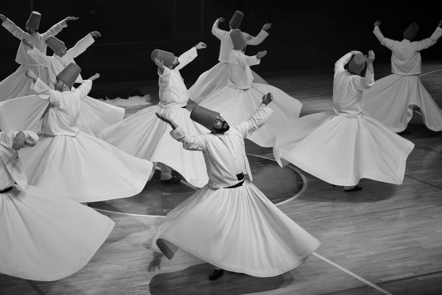 Whirling dervishes performing Sufi dance in black and white
