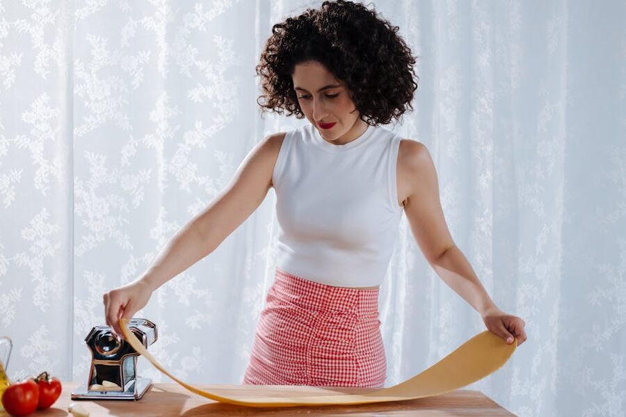 Woman using pasta roller for fresh pasta